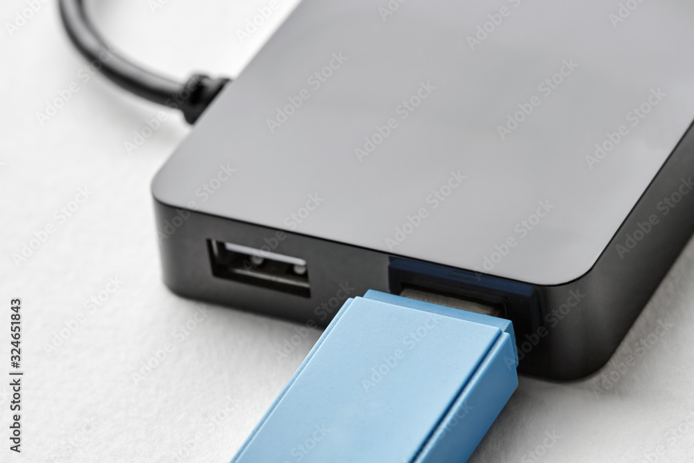 Black portable USB hub for four connections with usb flash drive on a ...