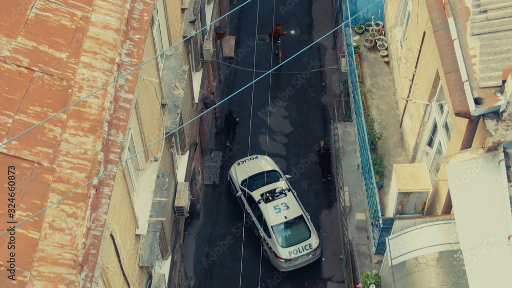 Drone aerial view of two armed policemen with pointed guns chasing a ...