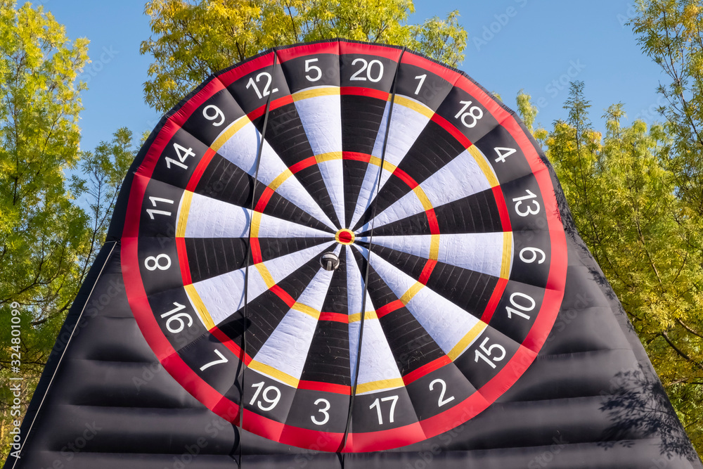 Giant inflatable dart board with velcro ball in autumn park. Stock ...