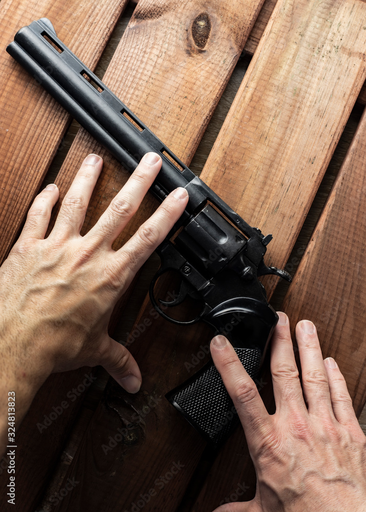Mano de hombres con pistola revólver aislado sobre un fondo de madera ...
