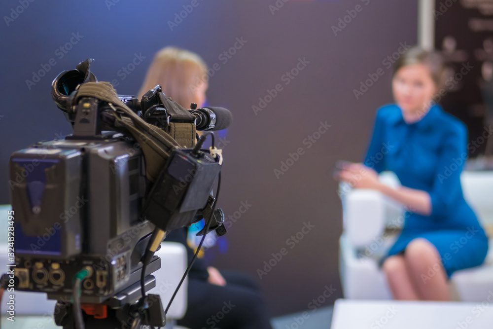 Television video camera recording interview in broadcast news studio ...