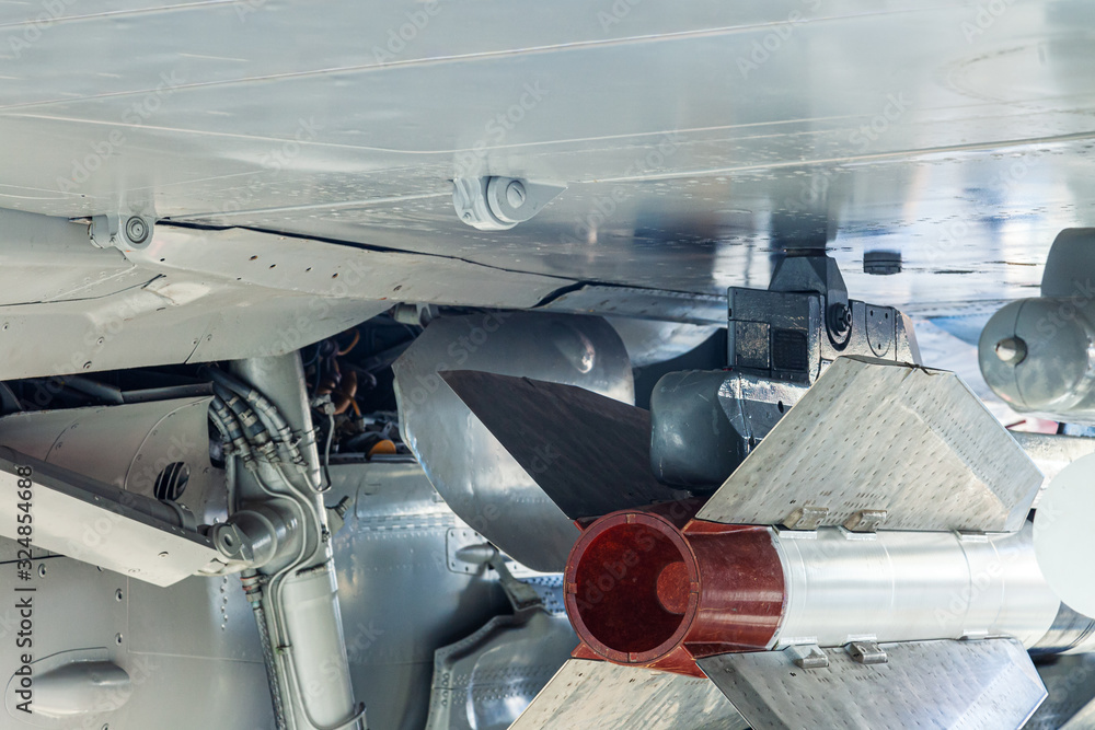A winged homing missile suspended under the wing of a fighter. Back ...