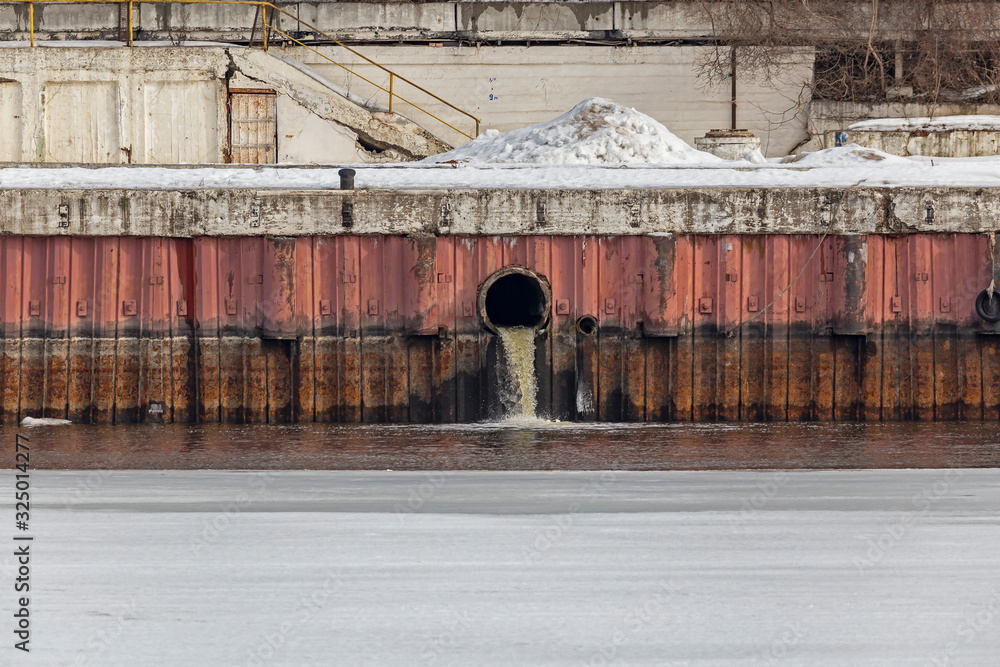 Sewer pipe in a concrete wall from which water flows into the reservoir ...
