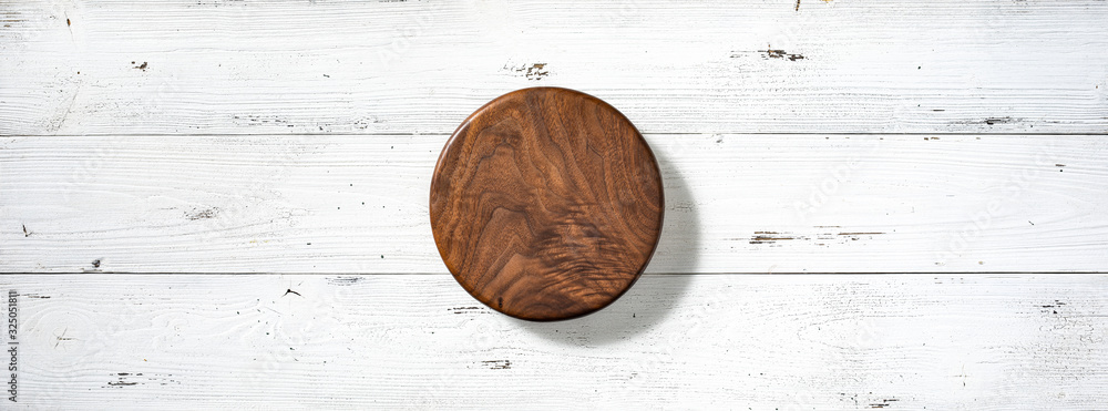 Round walnut pallets on white long wooden boards. Walnut wood texture ...