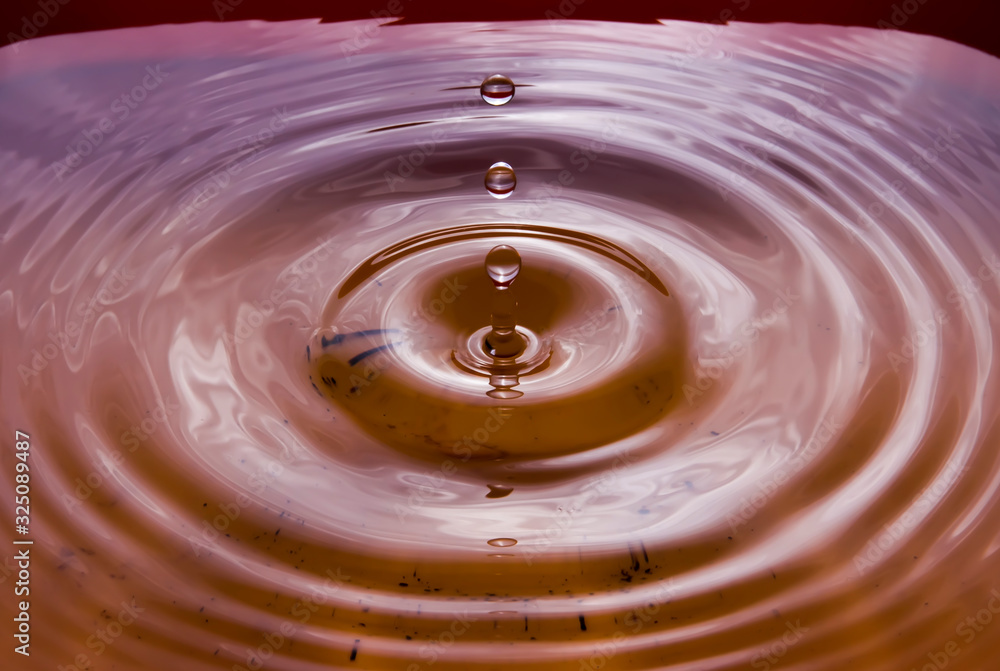Water droplets falling on the water surface create beautiful ripples on ...