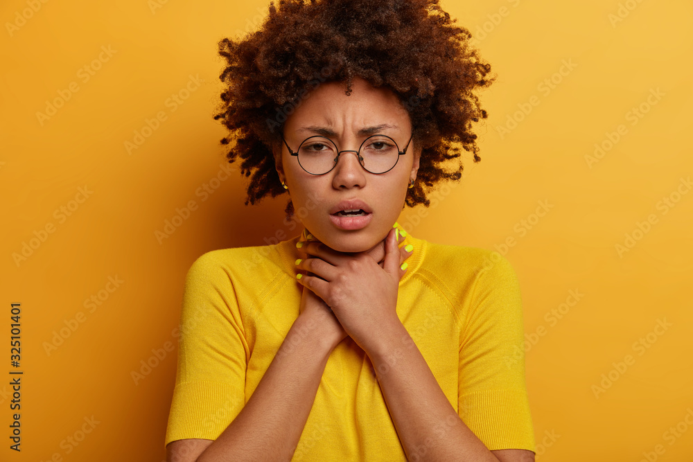 Close up shot of frustrated curly African American woman keeps hands on ...