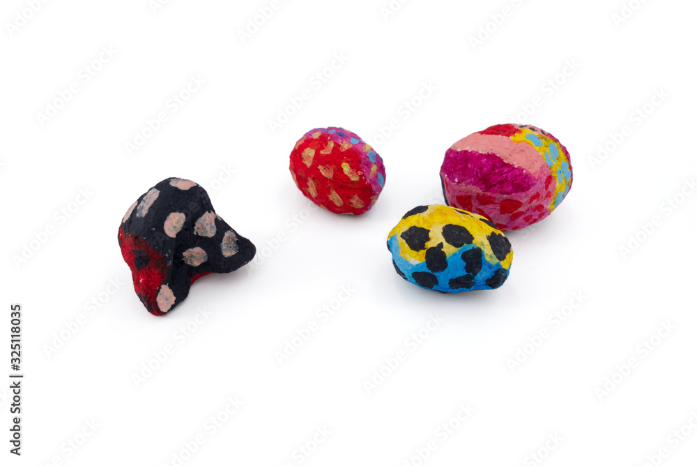 Round hand-crafted papier mache objects, painted in different colors ...