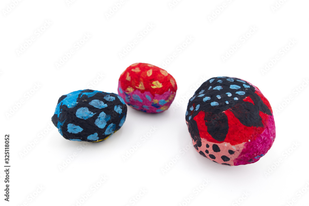 Round hand-crafted papier mache objects, painted in different colors ...