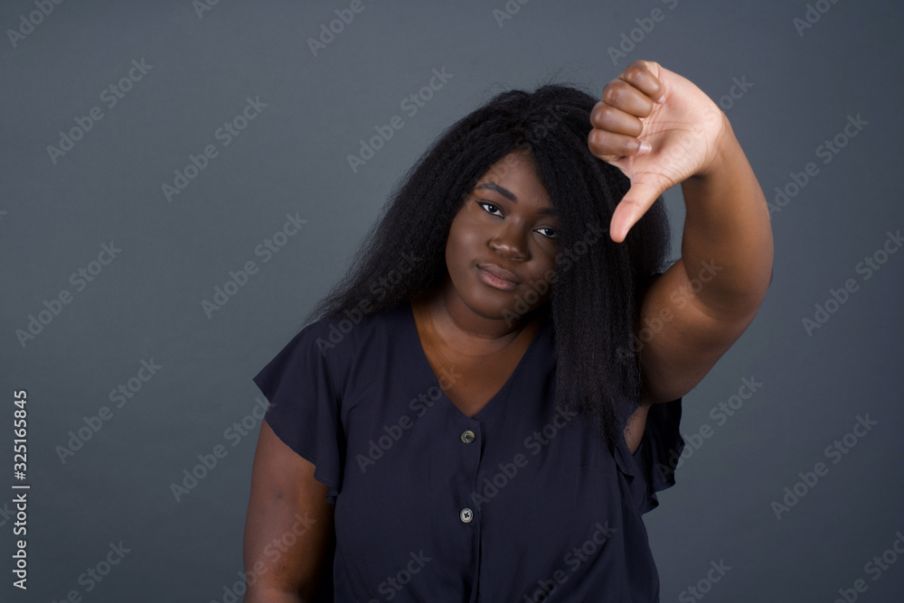 African American woman shows disapproval sign, keeps thumb down ...