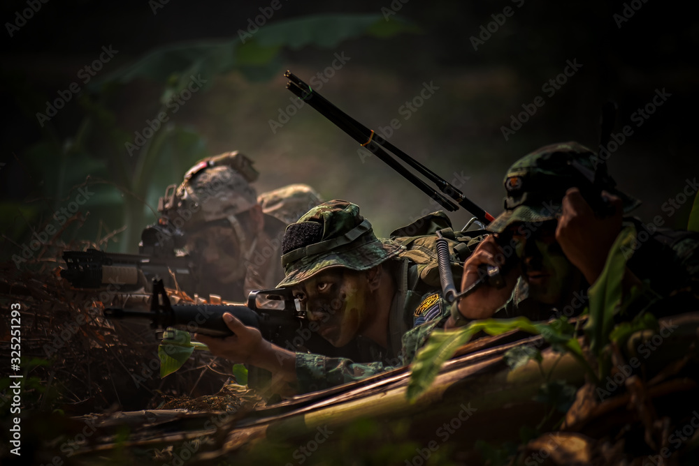 Soldier with gun are hiding in the forest and are ready for fighting ...