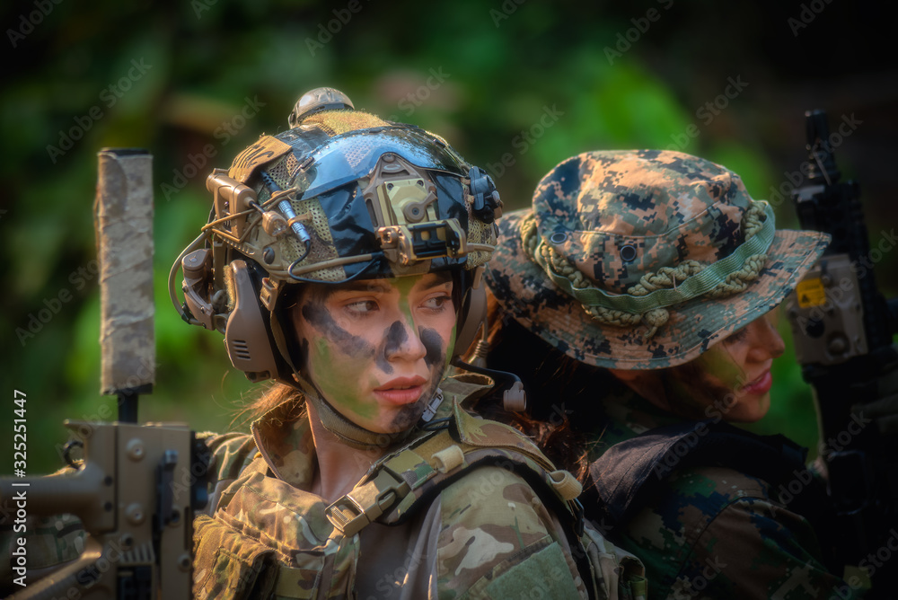 Two female soldiers are sitting with their backs and relax after ...