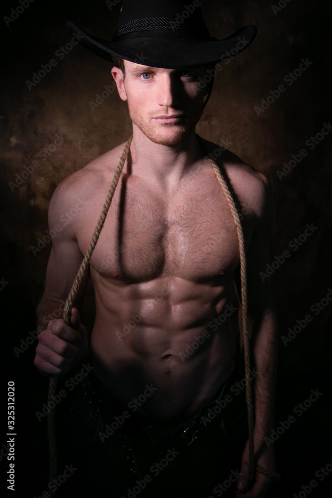 Foto de Handsome cowboy wearing a hat with barechest showing defined ...