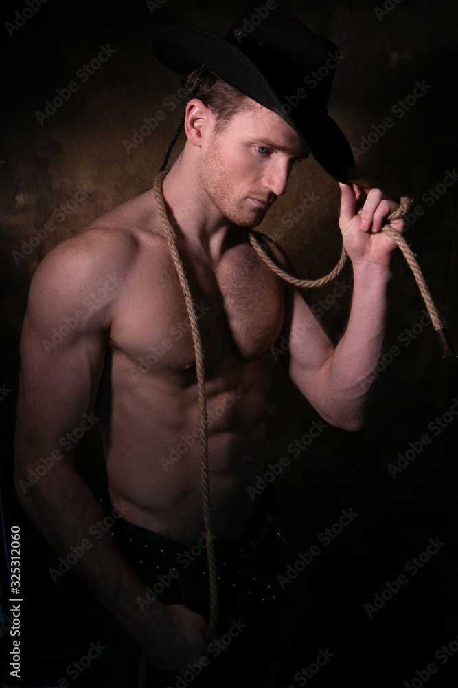 Handsome cowboy wearing a hat with barechest showing defined pecs and ...
