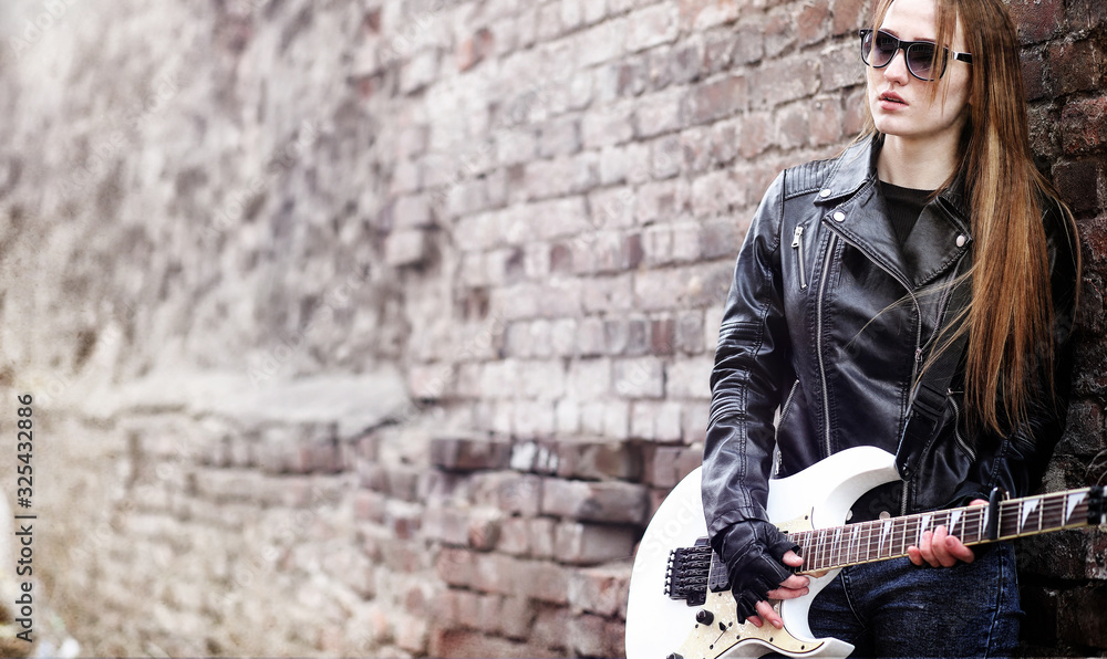 Beautiful young girl rocker with electric guitar. A rock musician girl ...