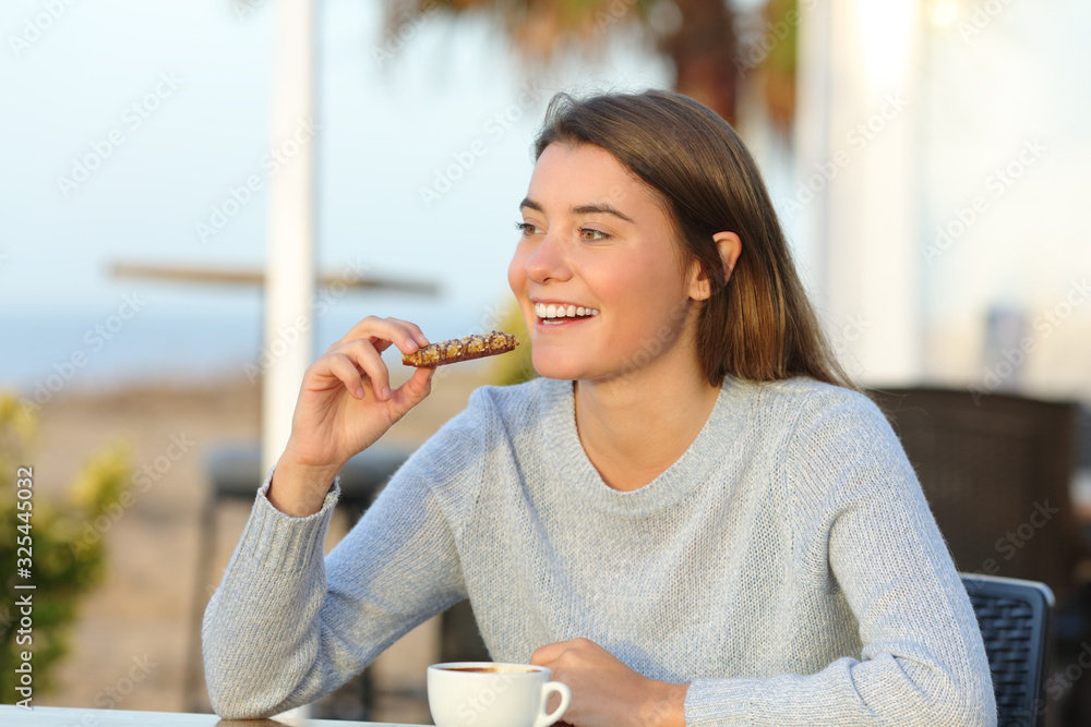 Happy girl eating a snack in a cafe terrace Stock Photo | Adobe Stock