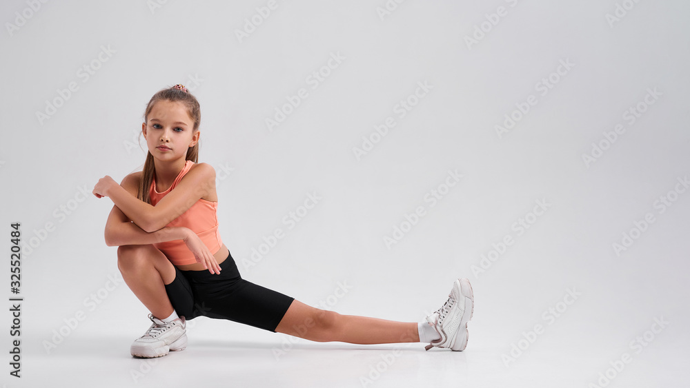 Flex for your health. Flexible cute little girl child looking at camera ...