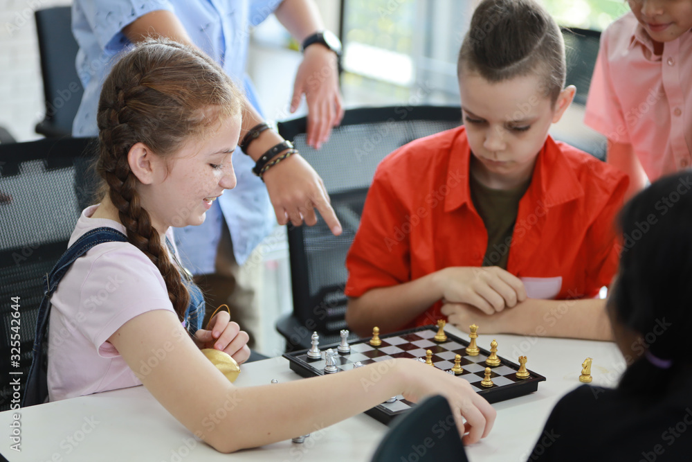 cute and smart kids sitting and playing chess in classroom (education ...