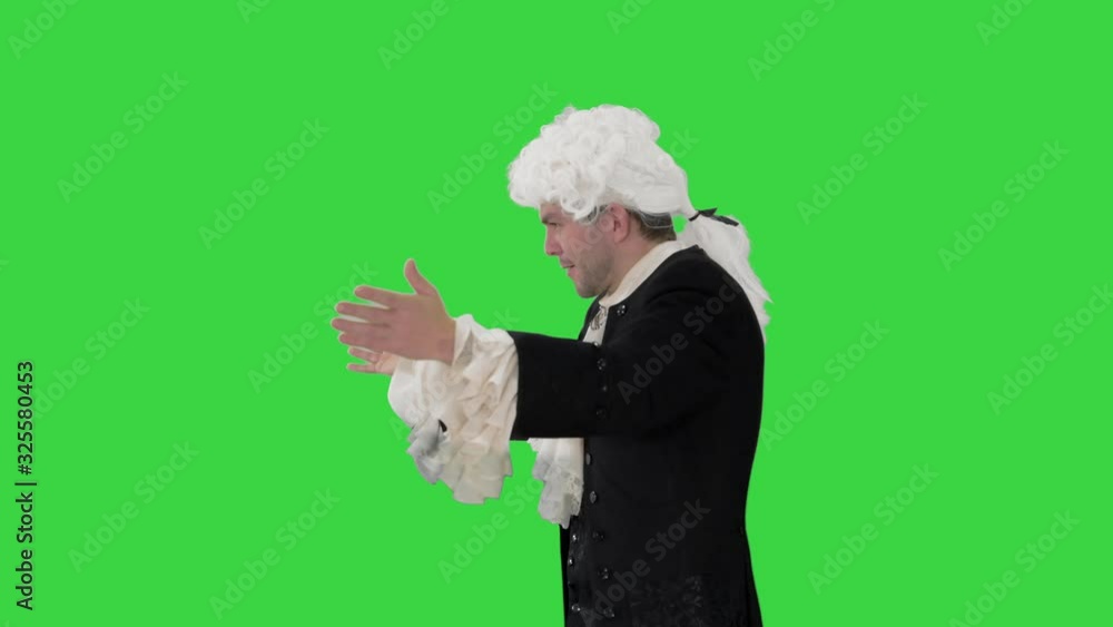 Man dressed like Wolfgang Amadeus Mozart conducting an orchestra on a ...