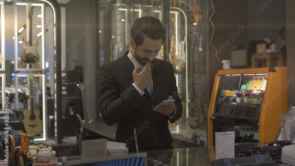 An upwardly mobile Middle Eastern man using a mobile phone - smartwatch ... An upwardly mobile Middle Eastern man using a mobile phone - smartwatch ...