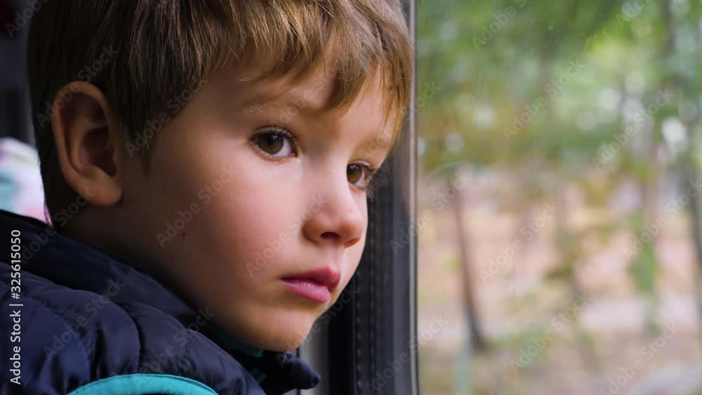 Vidéo Stock Child looking through window. Close-up shot of a kid ...