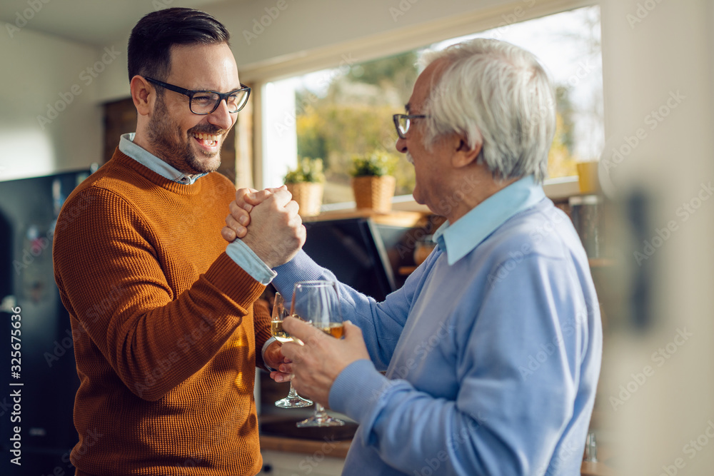 Happy man and his mature father giving a manly greet to each other ...