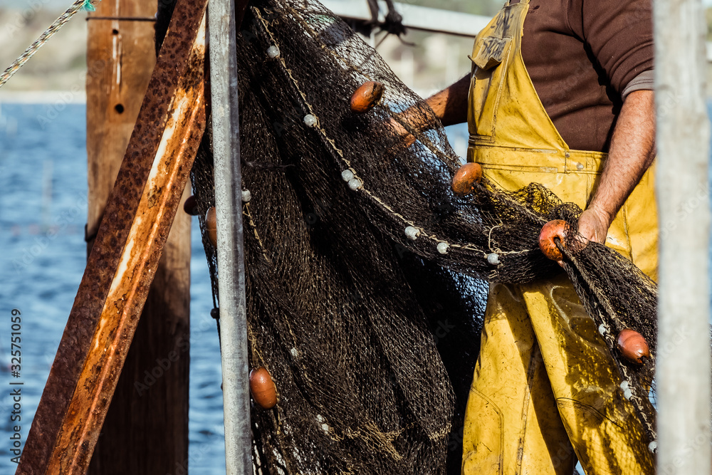 Mains d'un pêcheur en train de ranger ses filets de pêche Stock Photo ...