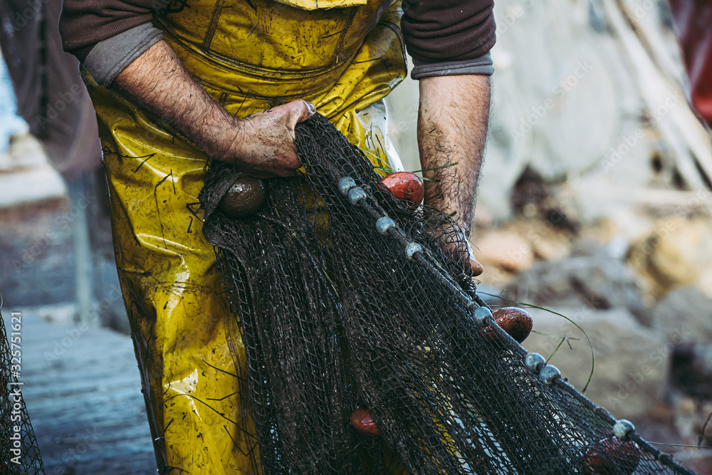 Mains d'un pêcheur en train de ranger ses filets de pêche Stock-Foto ...