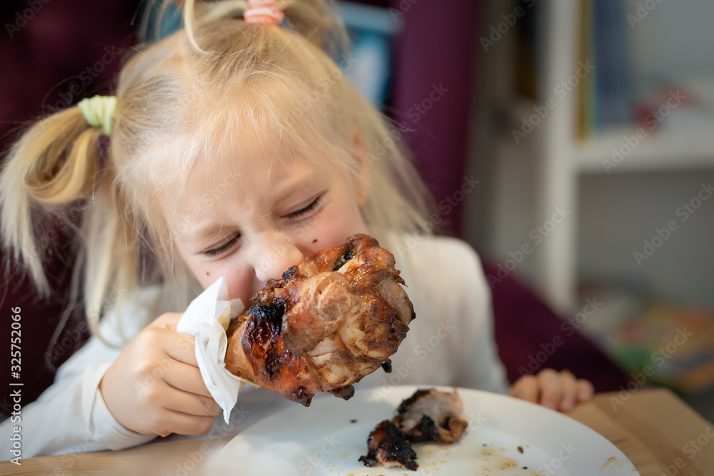 Cute adorable caucasian blond little girl portrait enjoy eating roasted ...