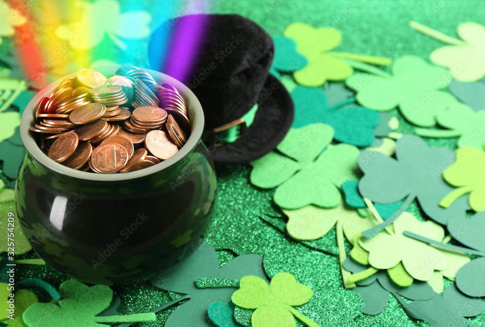 Pot with gold coins, hat and clover leaves on table, space for text. St ...