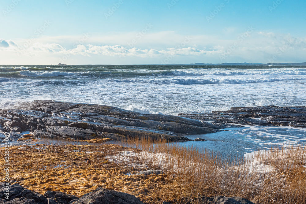 Sea waves crashing on stones with splash and foam in windy day by the ...
