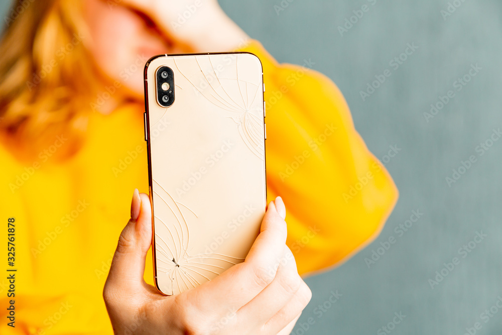 Broken phone in woman's hand. Sad lady holding broken glass and mobile ...