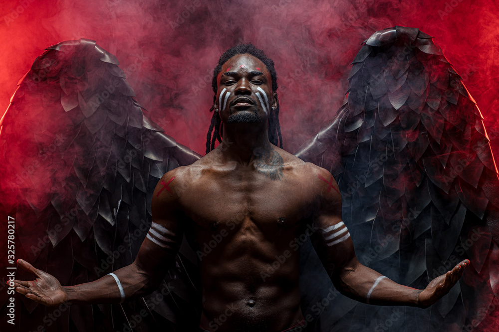 portrait of reckless dark angel with strong muscles, having athletic ...