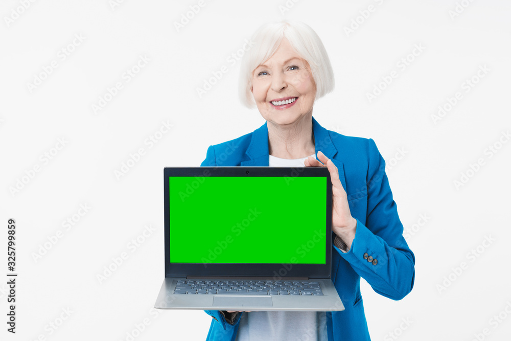 Cheerful mature woman showing chroma key screen laptop computer ...