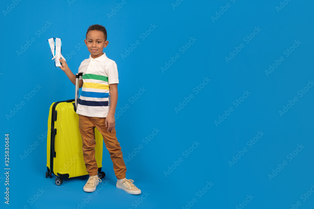 African-American traveler boy is ready for the trip, showing passport ...