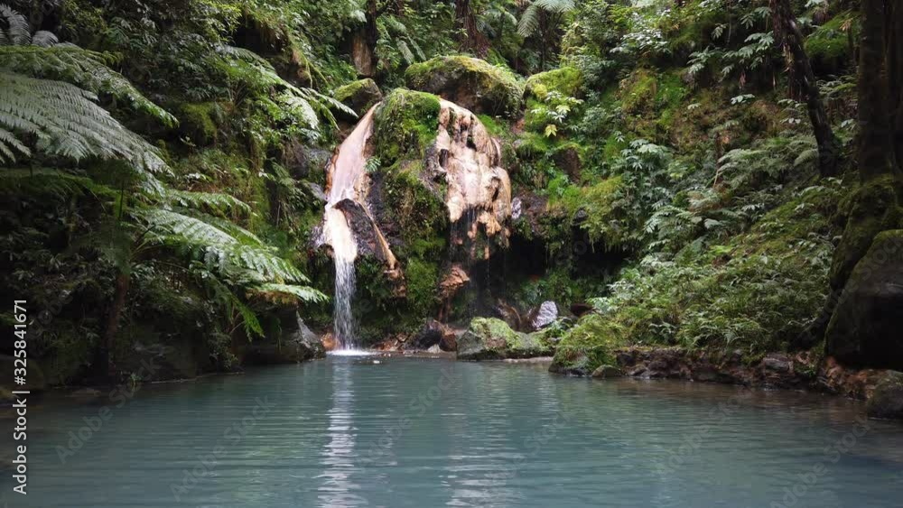 Blue lagoon of natural hot spring at "Caldeira Velha" where people swim ...