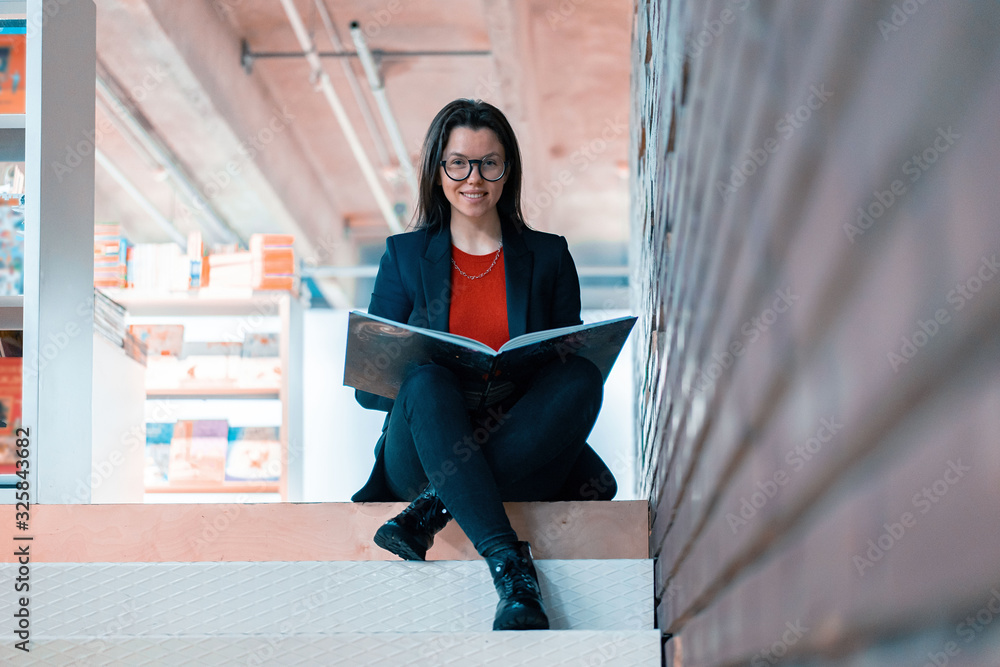 One Handed Woman Reading a Book On Steps And Smiling. Concept Of ...