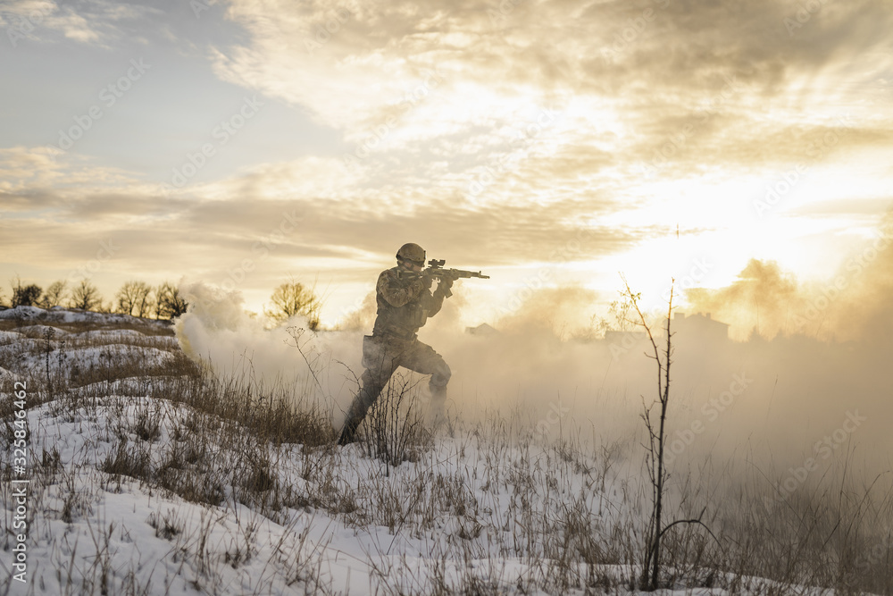 Soldier army man running through the smoke and explosions sun backlight ...