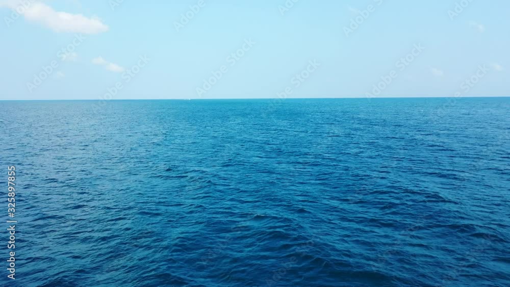 Ocean background, bright blue sky with white clouds and tranquil water ...