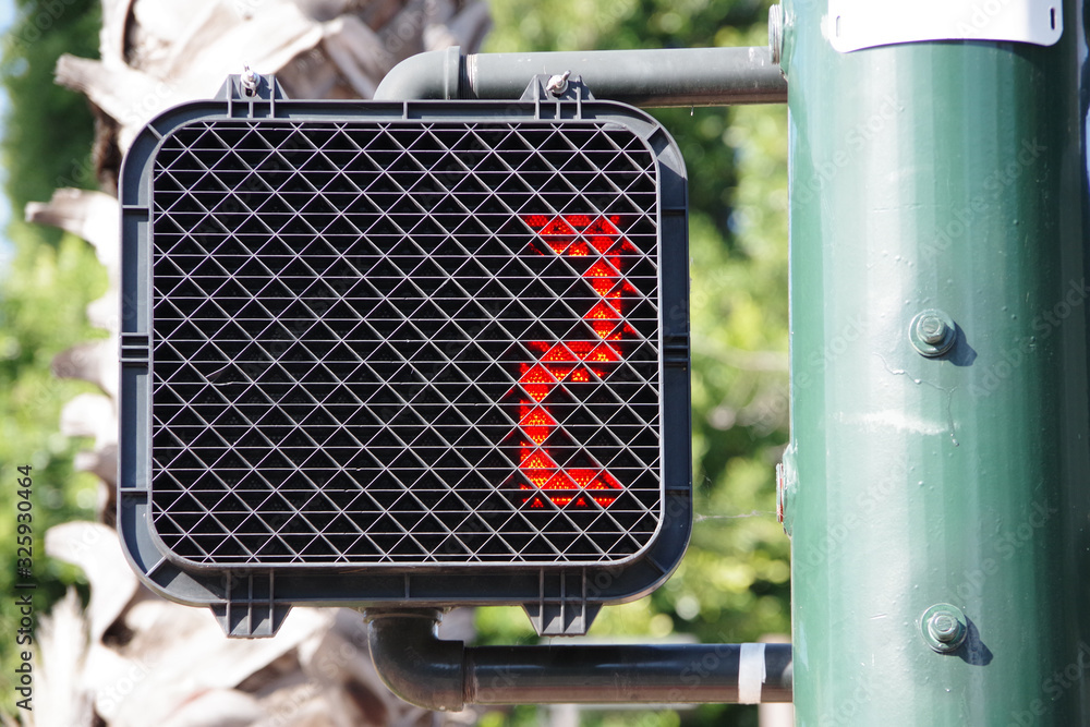 Pedestrian crosswalk traffic signal at a city intersection warning that ...