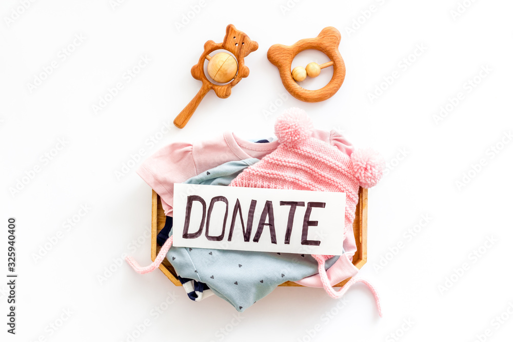 Donate text. Box with clothes for kids on white background top-down ...