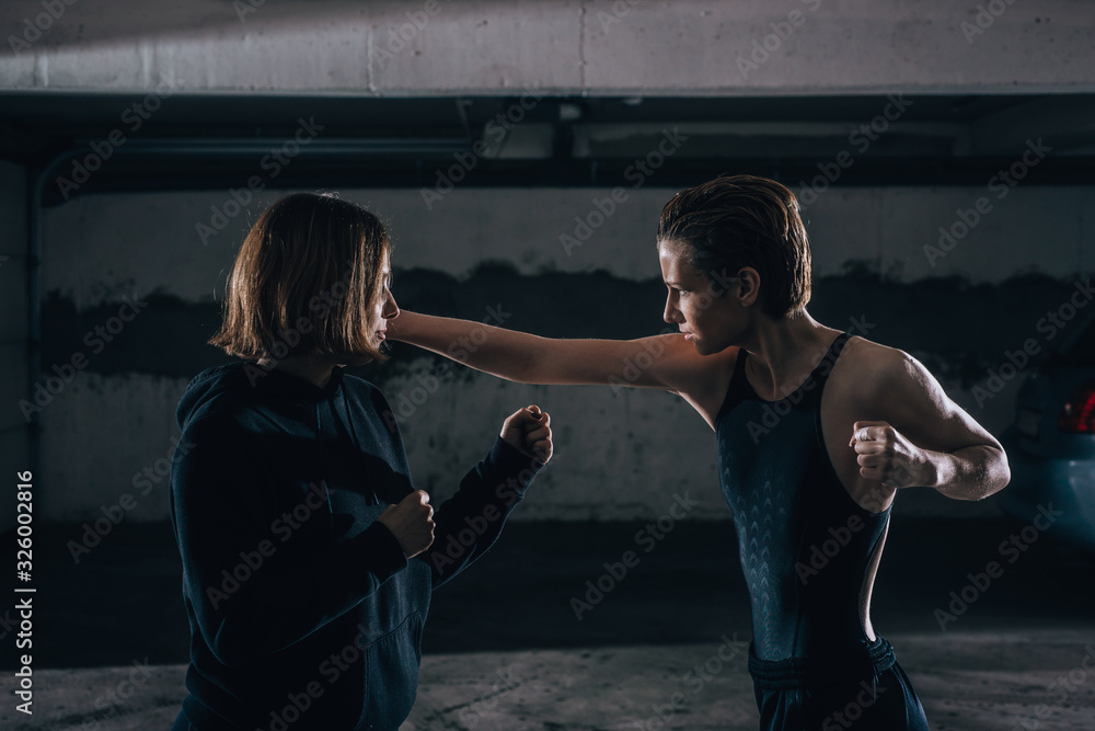 Silhouette picture of two young women practicing fighting inside the ...