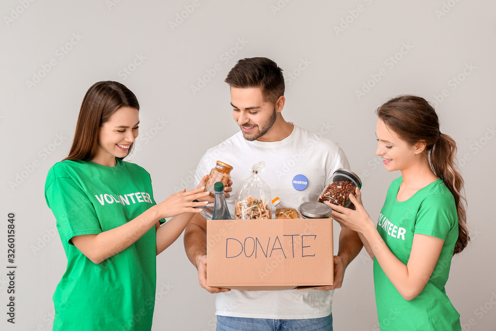 Volunteers with donations for poor people on light background Stock ...