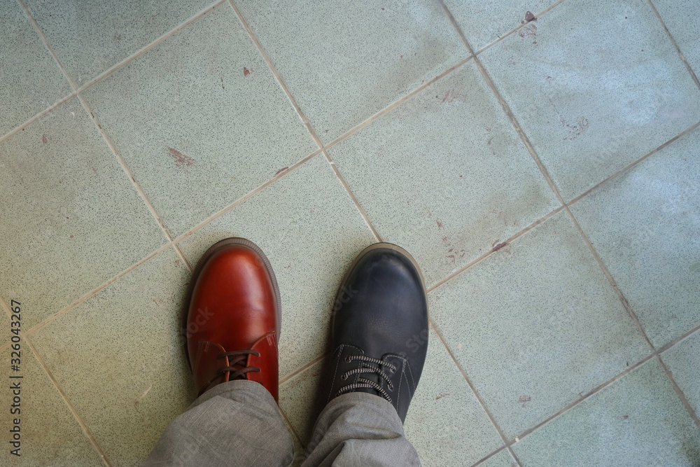 Foto de Closeup upper of mismatched shoes, a man wearing two different ...