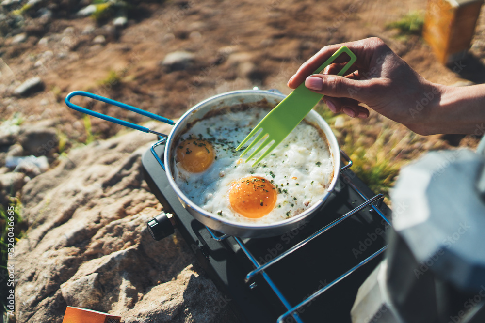 person cooking fried eggs in nature camping outdoor, cooker prepare ...