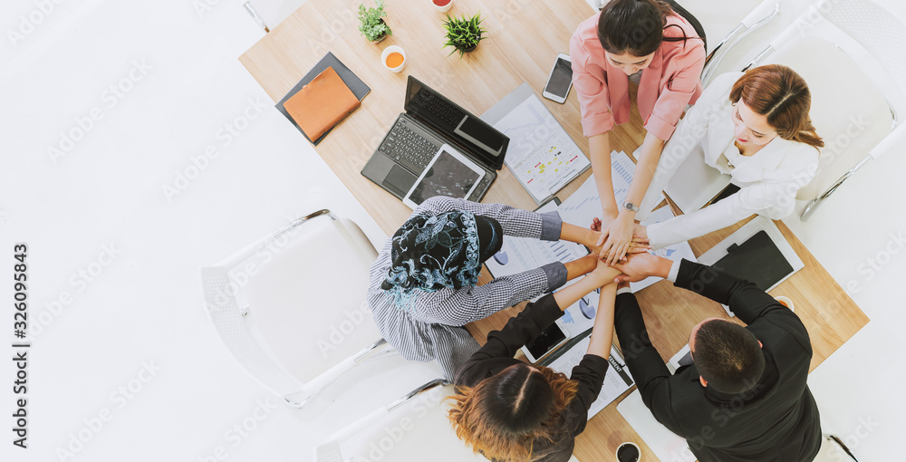 Top view of businessmen and businesswoman standing and stacking hands ...