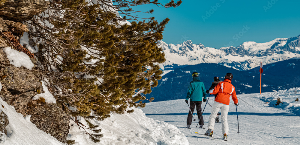 Beautiful alpine winter wonderland with passing by ski drivers at ...