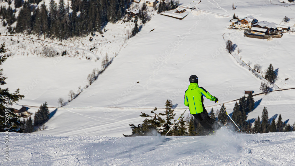 Ski driver making a sharp turn on a terrain edge with flying snow at ...