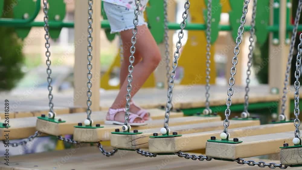 A child with pink shoes is balancing and playing on the colorful ...