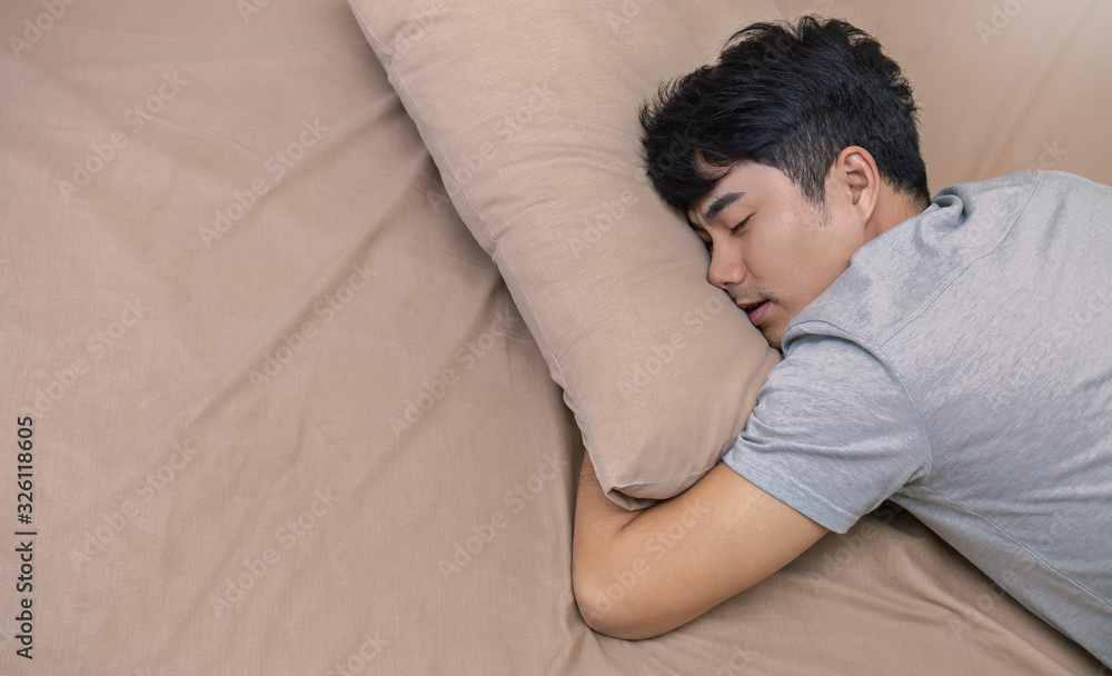 Foto de Portrait of young asian man with attractive smile sleeping ...