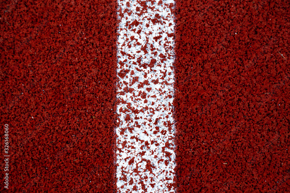 white dividing strip on red highway pavement with copy-space, road ...